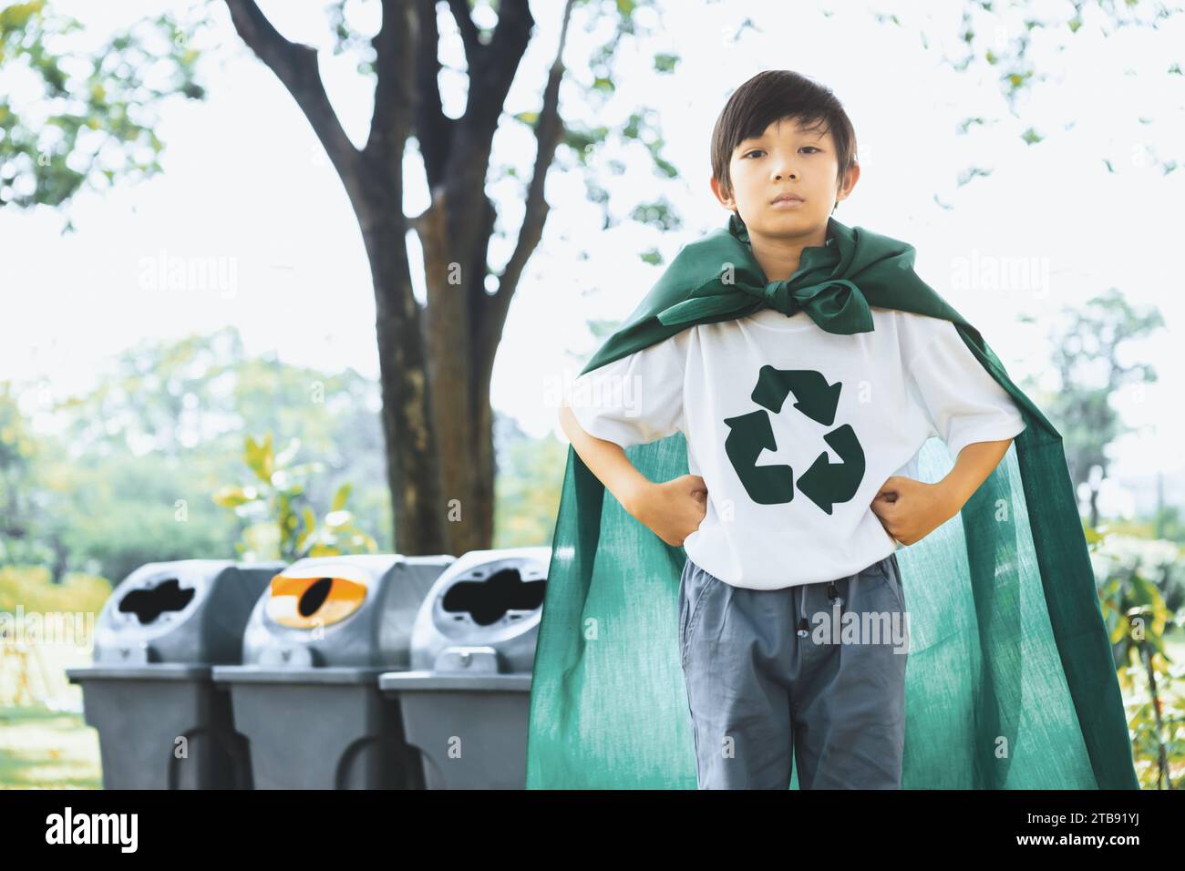 Cheerful young superhero boy with cape and recycle symbol promoting ...