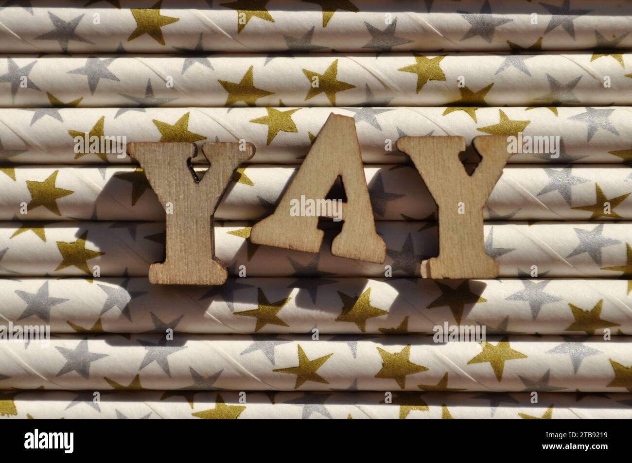 Yay, word in wooden alphabet letters isolated on background of gold and ...