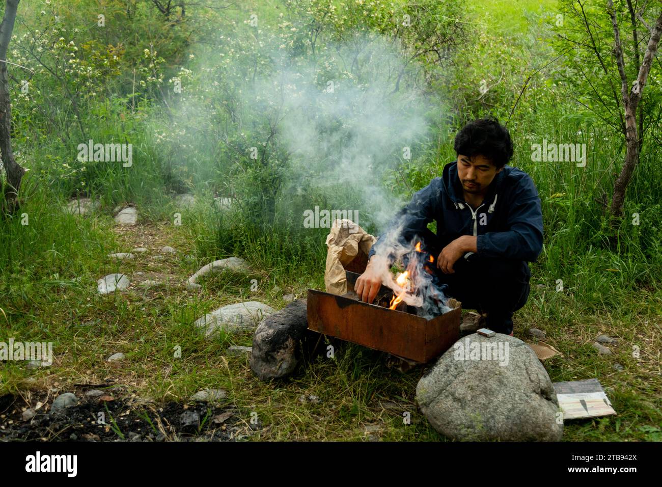 Man lighting a fire in the in the brazier Stock Photo - Alamy