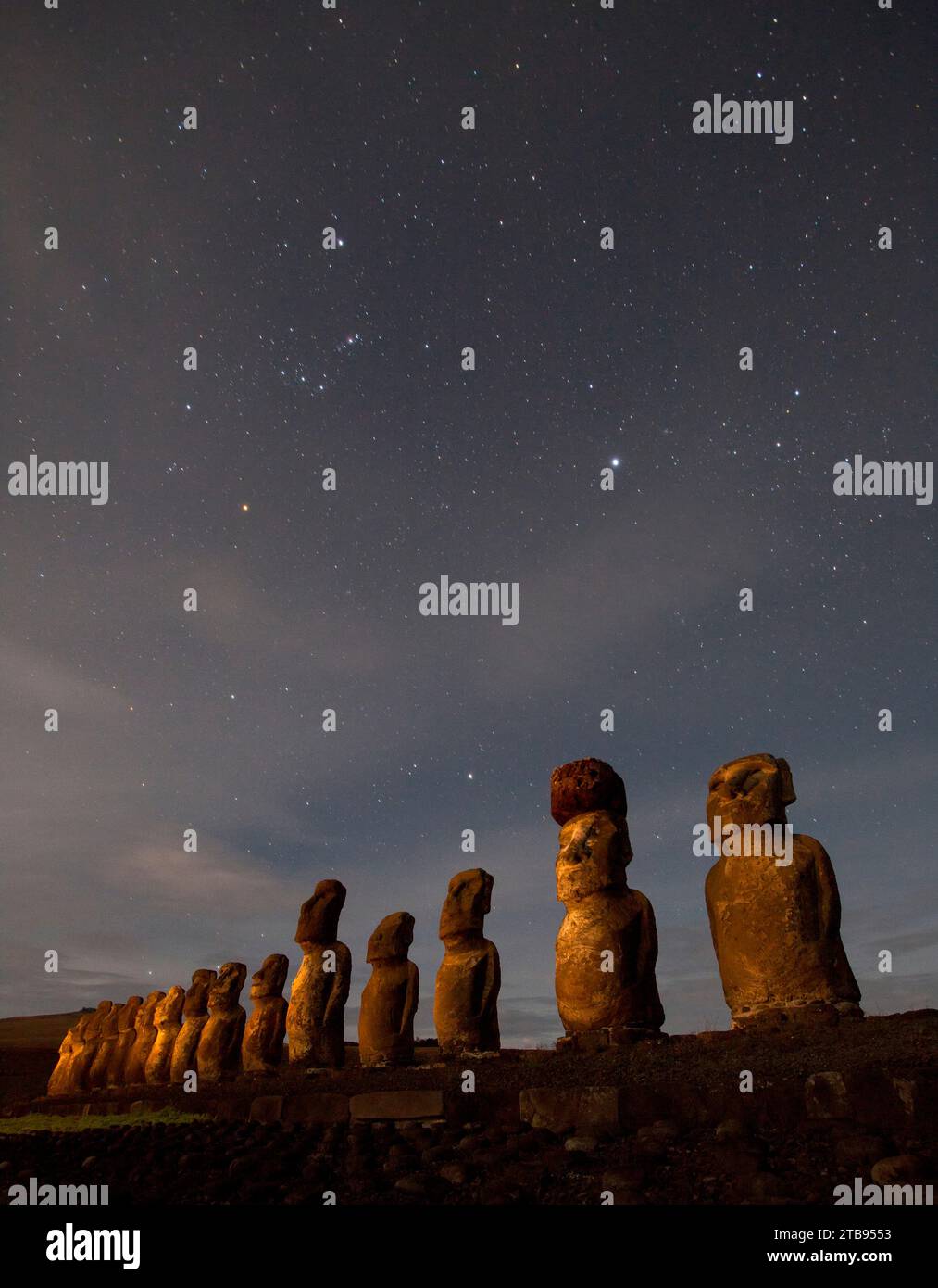 Moai stand at night illuminated beneath a sky full of stars on Easter ...