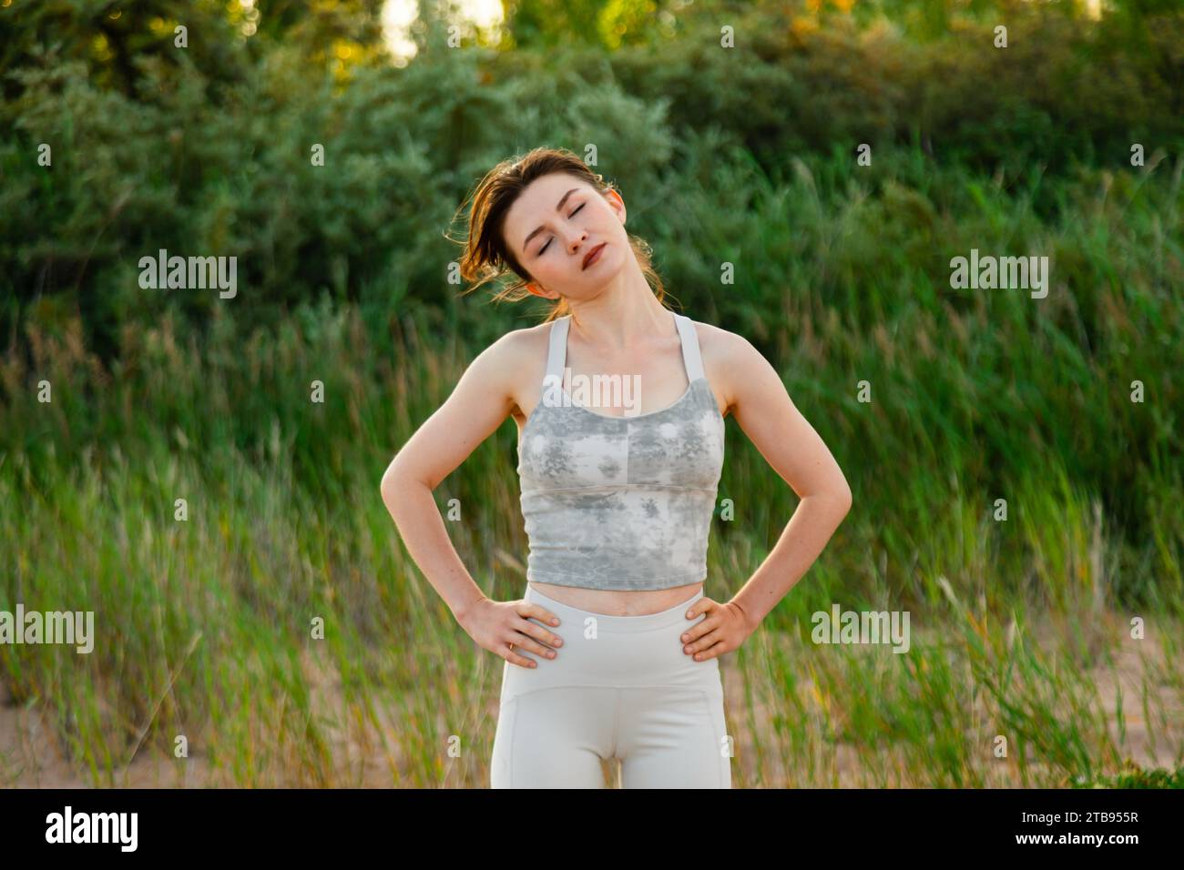 Fit sportive woman exercising outside, warming up before training ...