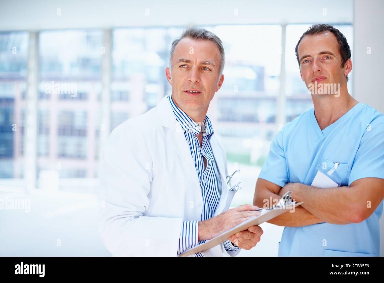 Doctors, men and clipboard in hospital together for thinking, space and ...