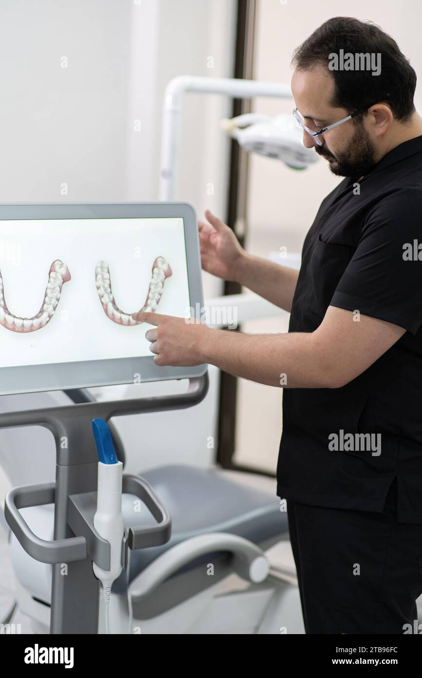 Specialist in uniform pointing to jaws models on computer screen using ...