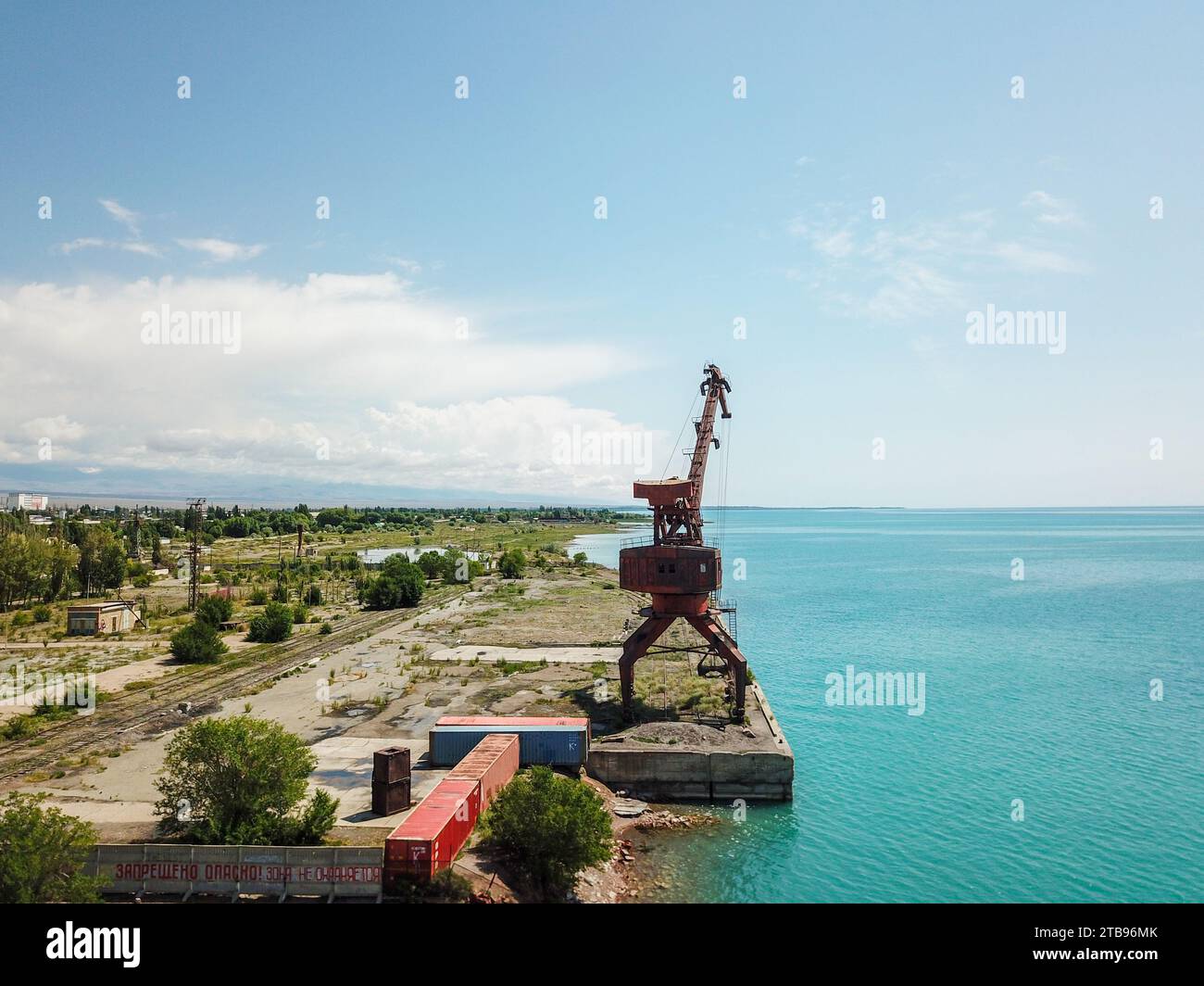 Aerial view of abandoned port with rusted quay cranes on a lake shore ...