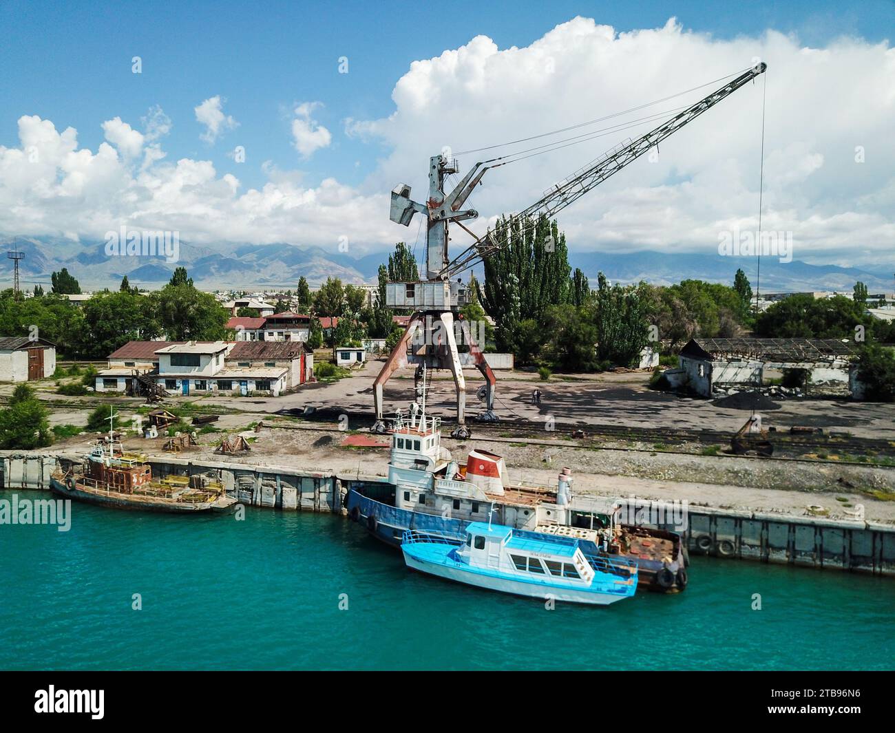 Aerial view of abandoned port with rusted quay cranes on a lake shore ...