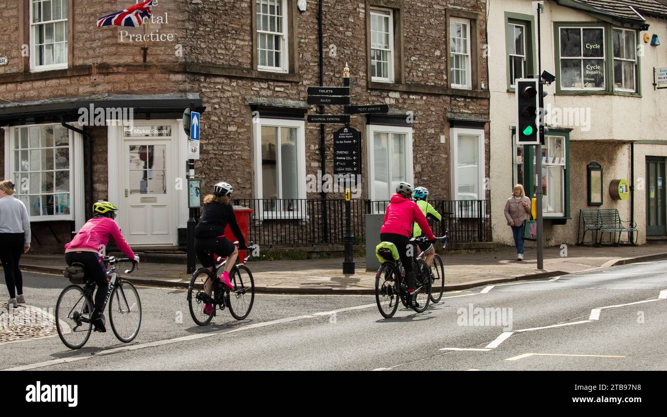 Women cyclists on road bikes cycle through Kirkby Stephen town centre ...
