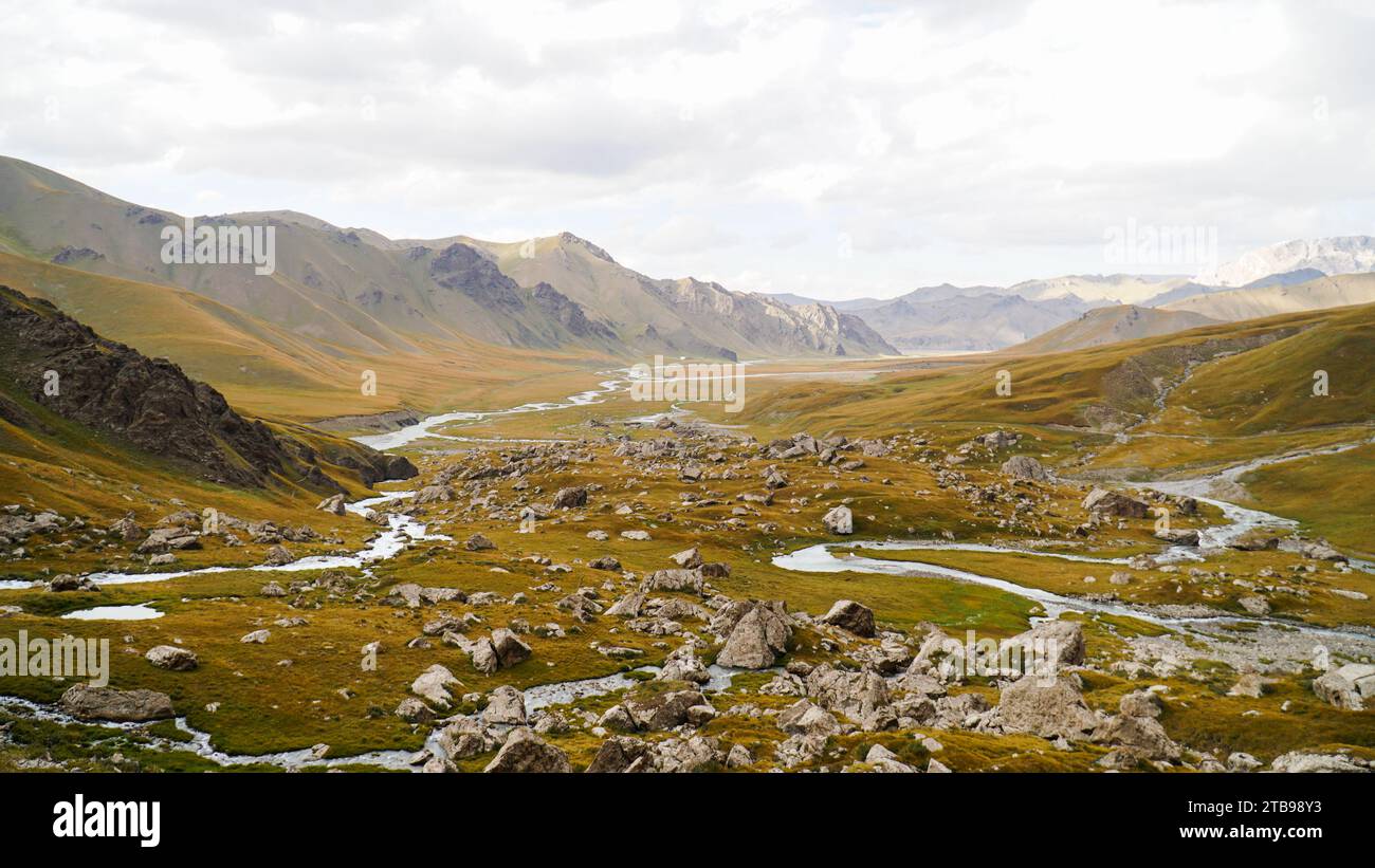 Valley surrounded with mountain and flowing water Stock Photo - Alamy