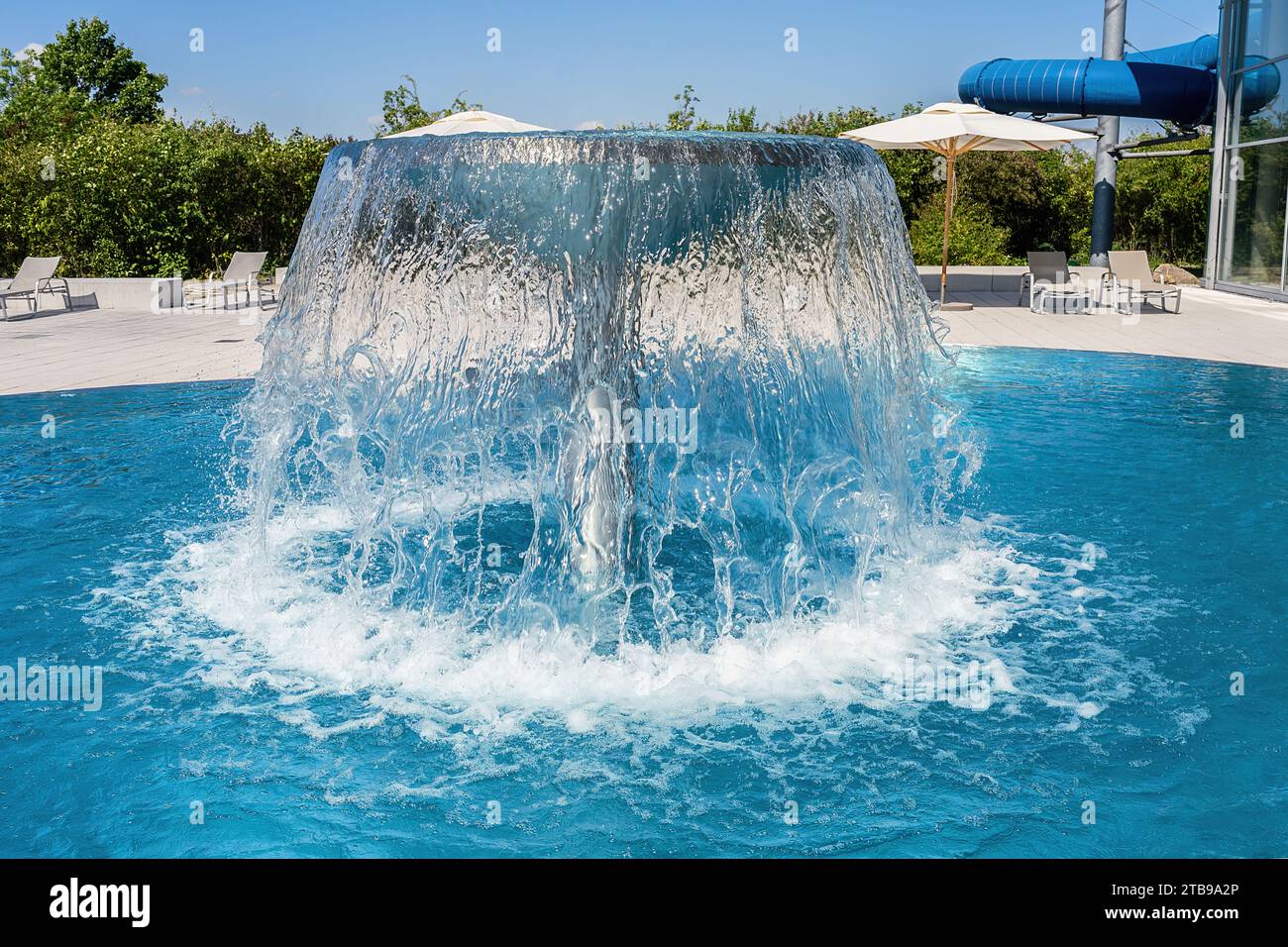 Waterfall mushroom feature in a swimming pool creating a large splash ...