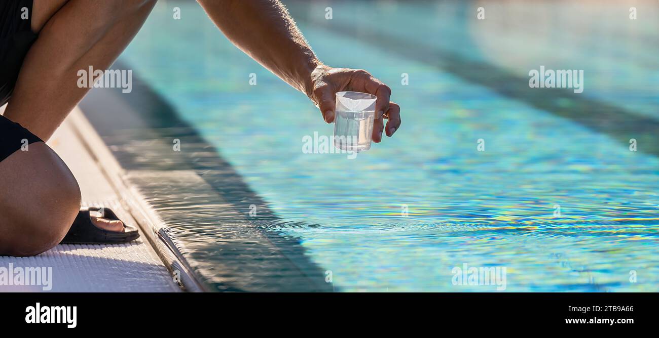 Hand holding a small container to take a water sample from a swimming ...