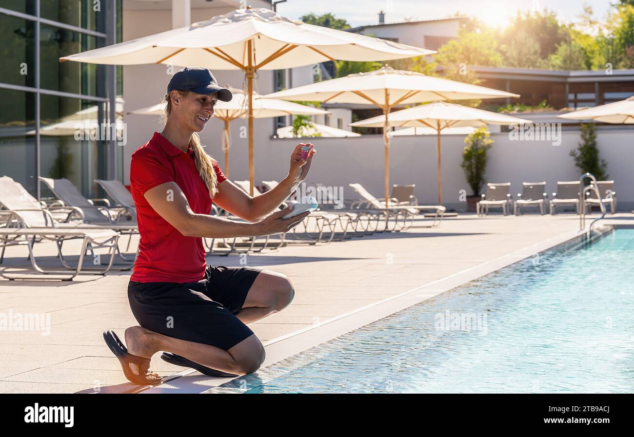 Lifeguard smiling while conducting pool water quality test Stock Photo ...