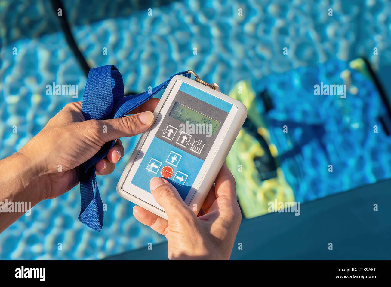 Hands holding a remote control for an automated pool cleaning robot ...
