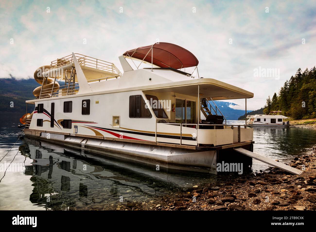 Vacation houseboats parked at a dock on the shoreline of Shuswap Lake ...