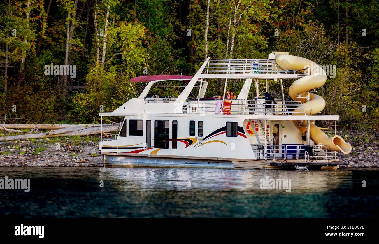 A family enjoying a houseboat vacation while parked on the shoreline of ...
