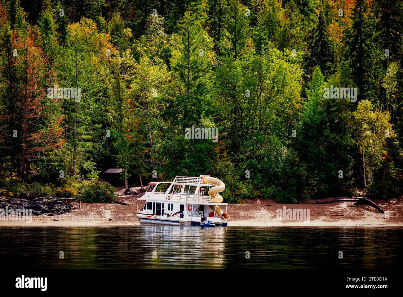 A family enjoying a houseboat vacation while parked on the shoreline of ...