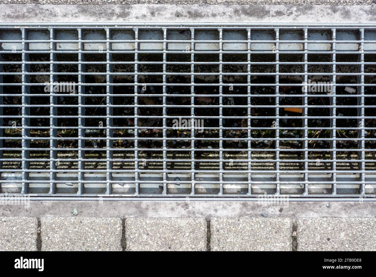 Gray metal grating with rectangular cells on a drainage channel on a ...