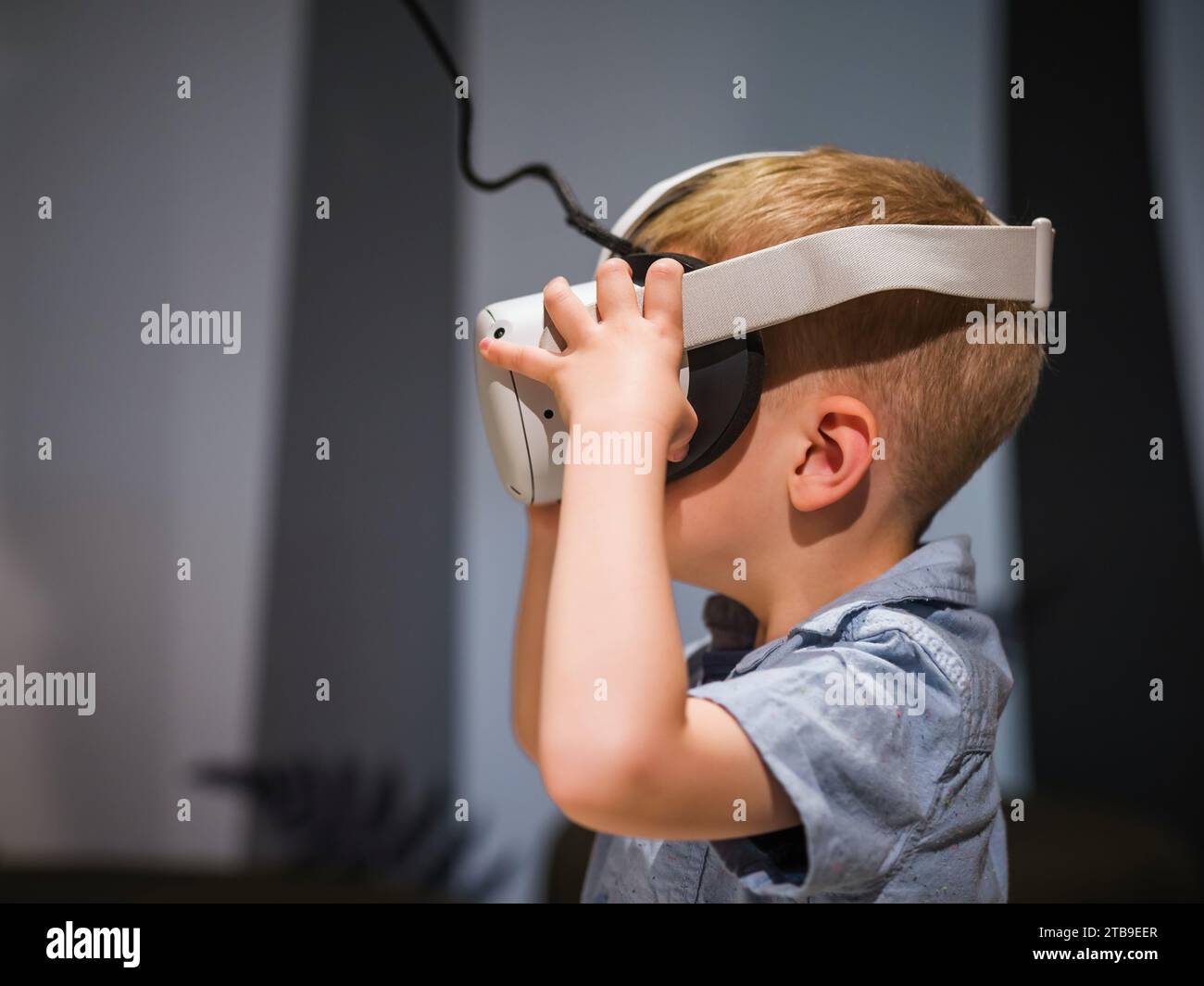 Little boy wearing VR headset in the museum playroom, engaged exploring ...