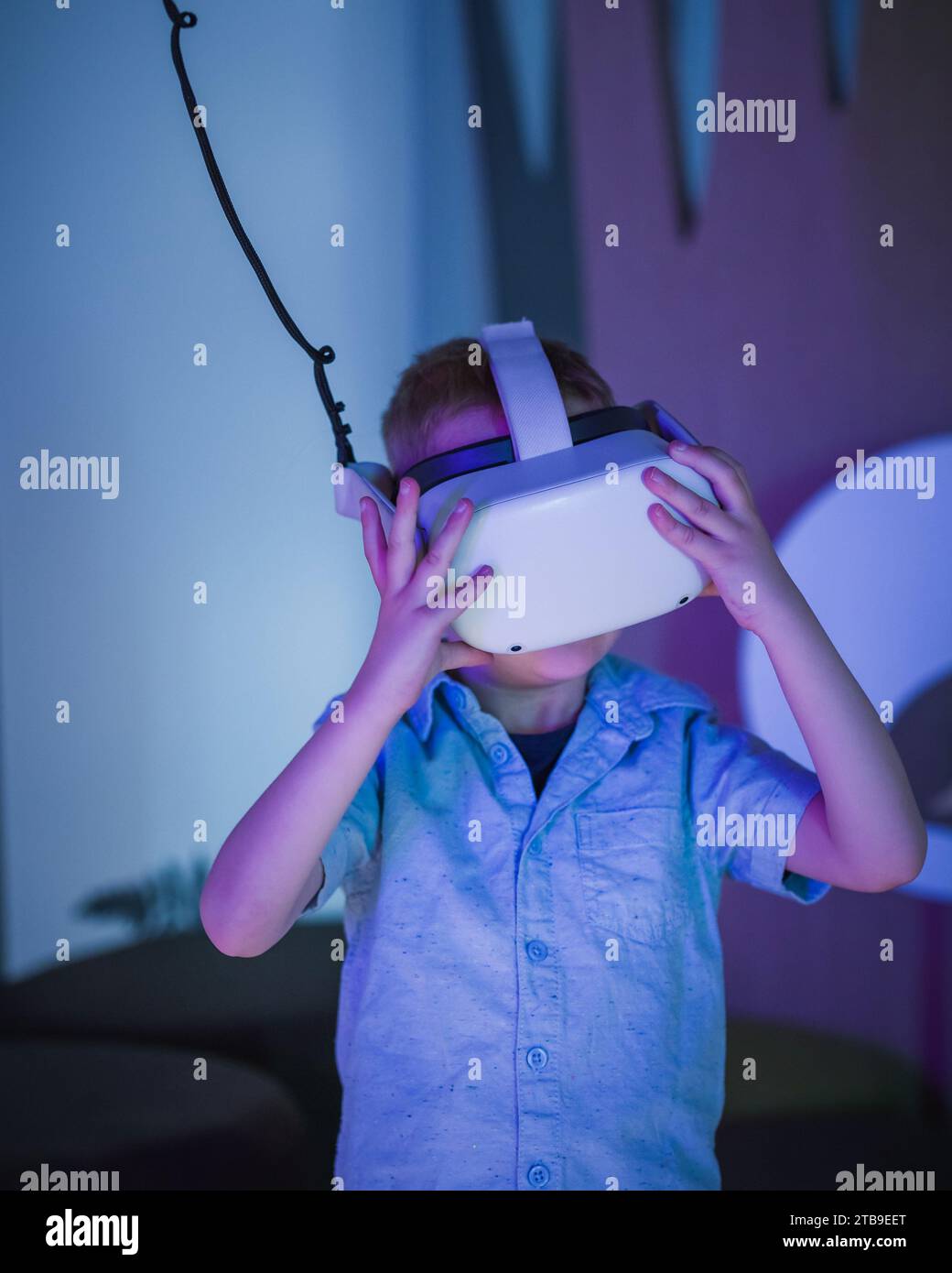 Little boy wearing VR headset in the museum playroom, engaged exploring ...