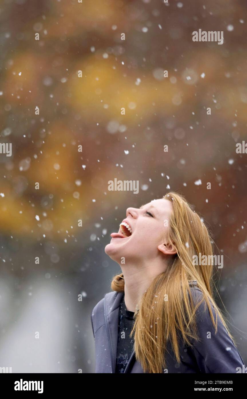 Young woman spends time outside during the first snow of winter ...