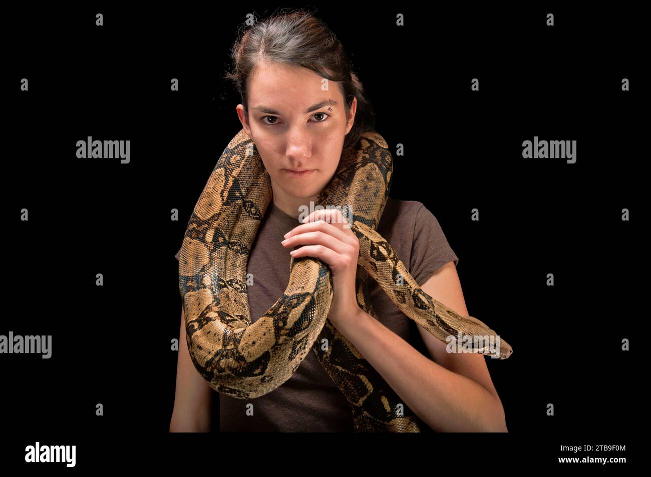 Young woman holds a Red-tailed boa constrictor (Boa constrictor ...
