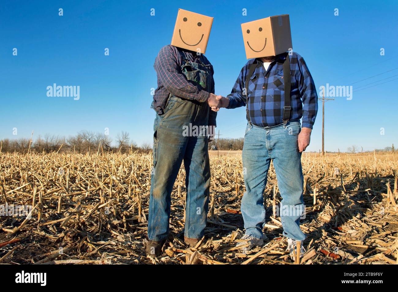 Two farmers with smiling box heads shake hands; Lincoln, Nebraska ...