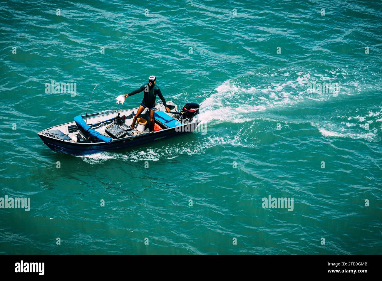 High perspective view of smiling fisherman showing off his catch in ...