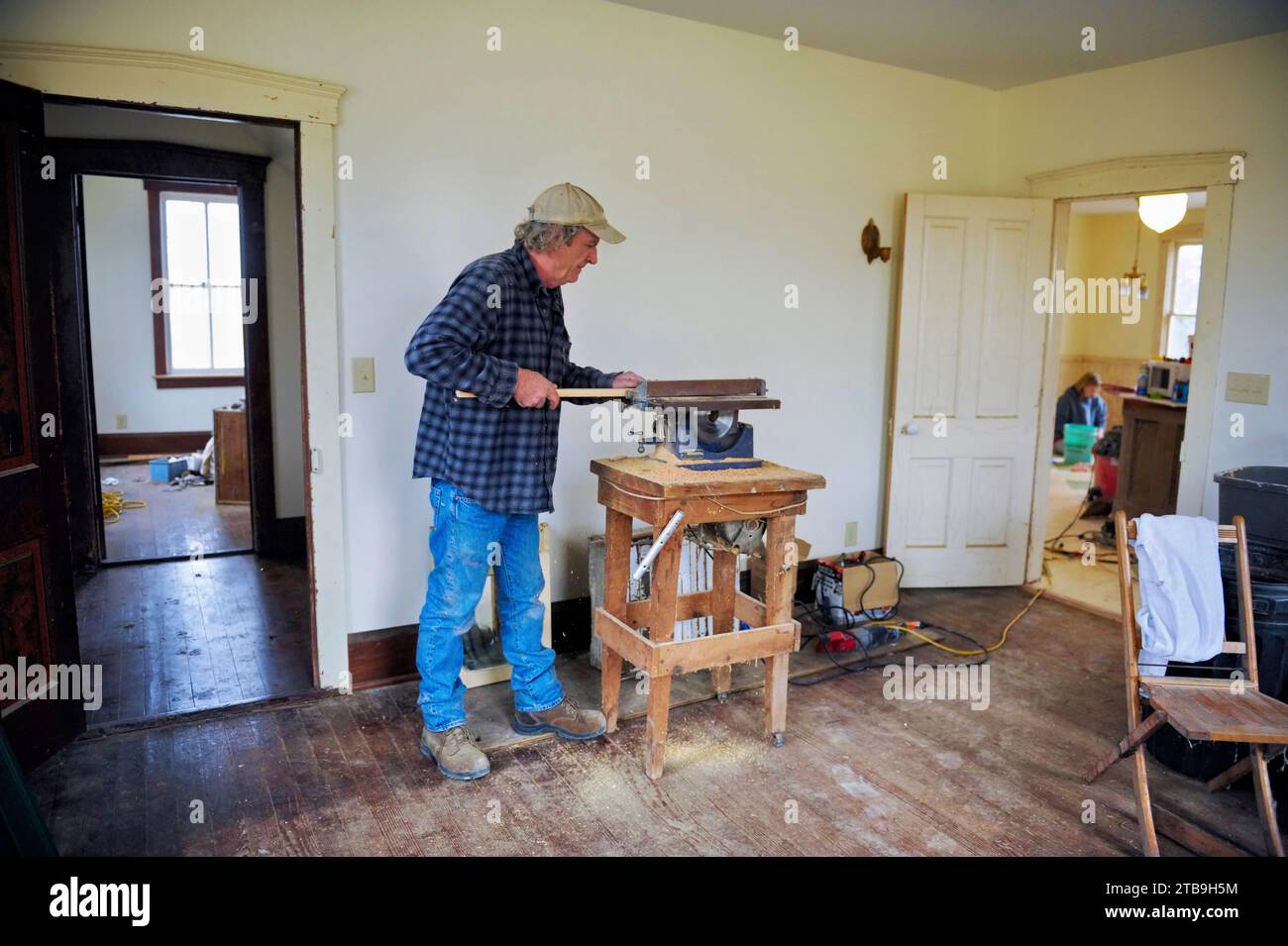Carpenter works to renovate an old farmhouse; Dunbar, Nebraska, United ...