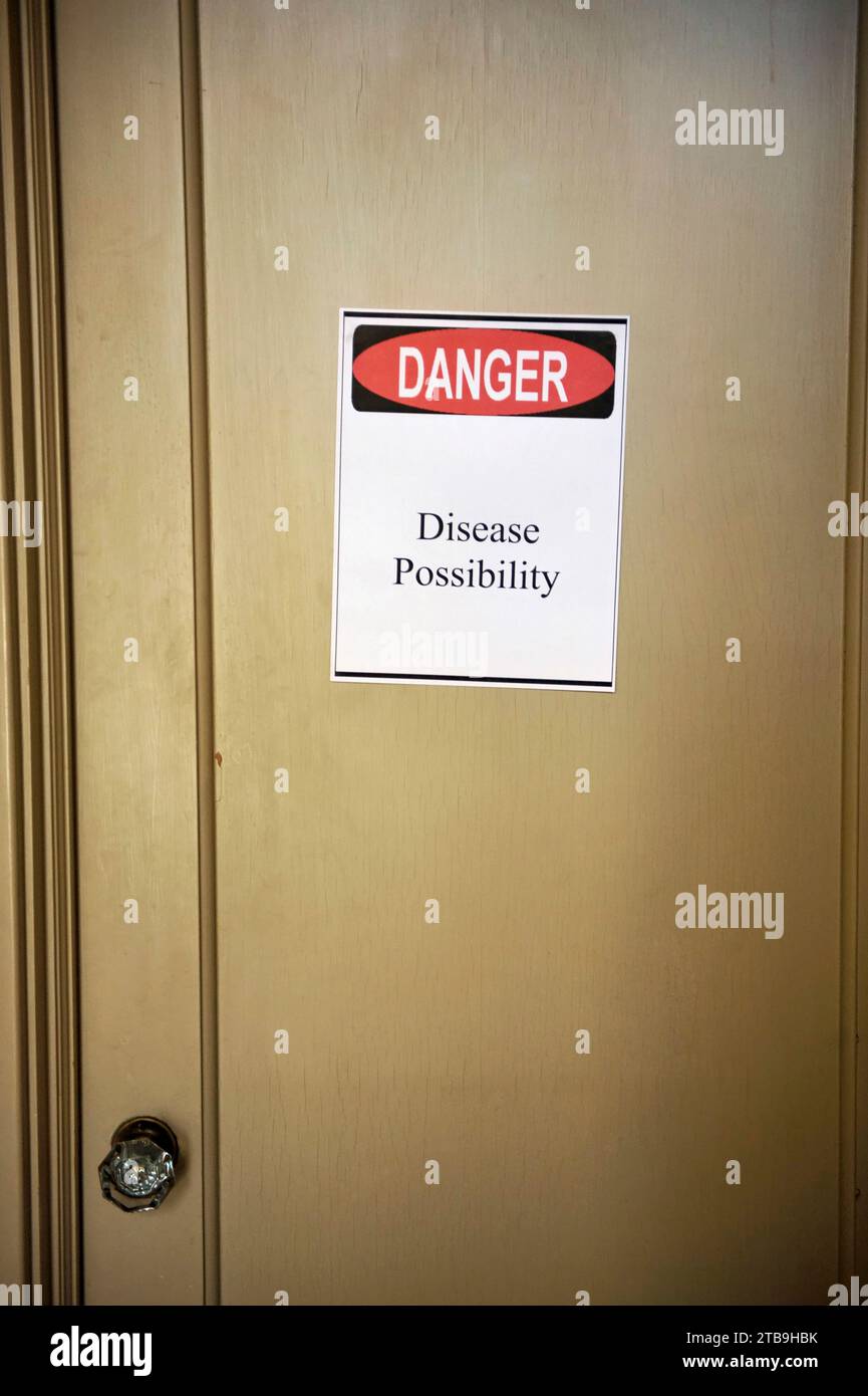 Danger sign on a closed door to prevent a risk of disease transmission ...