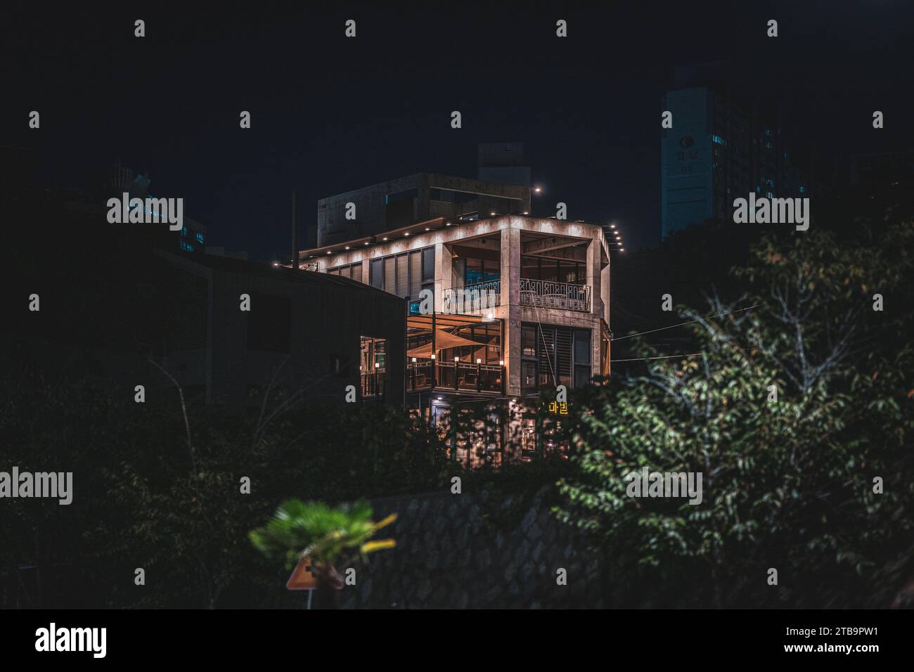 A small, single-story building illuminated by bright lights shining ...