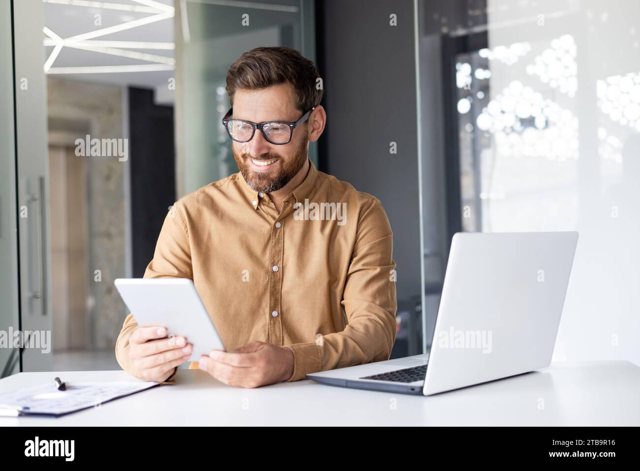 A young male programmer developer works in the office at the table at ...