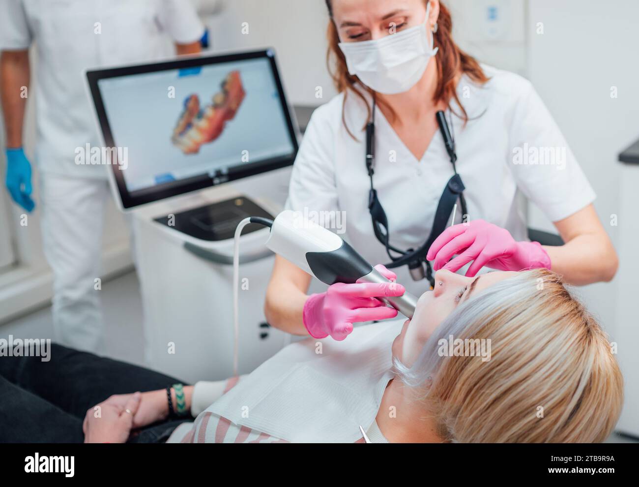 Dentist female doctor in uniform using intraoral 3D dental scanner ...