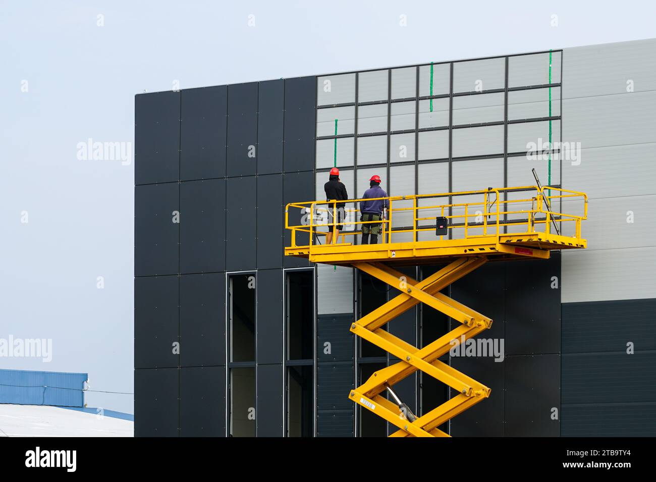 Large elevated aerial scissor lift working platform with workers ...