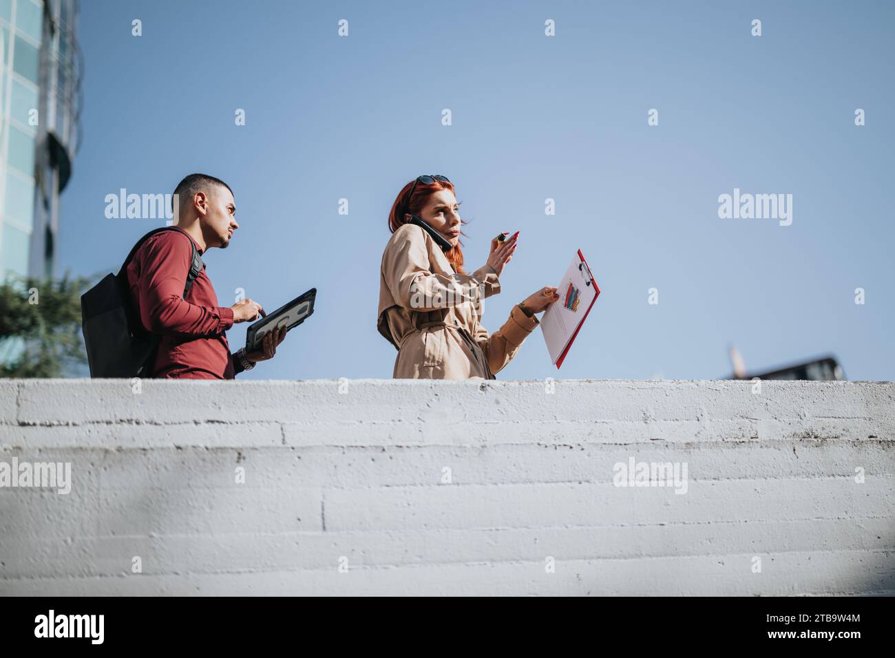 Young business people collaborating in urban setting, brainstorming ...