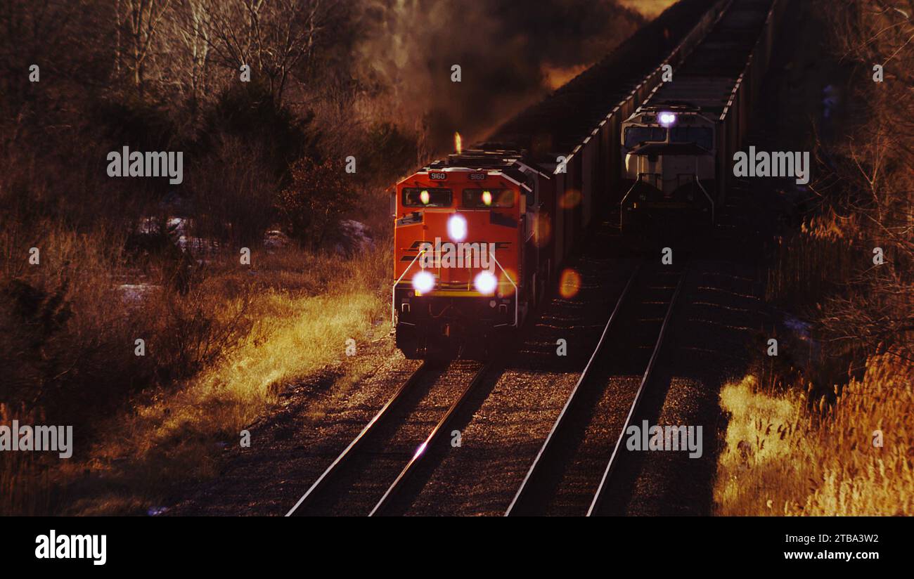 Single engine freight train transporting coal passes a stationary unit ...