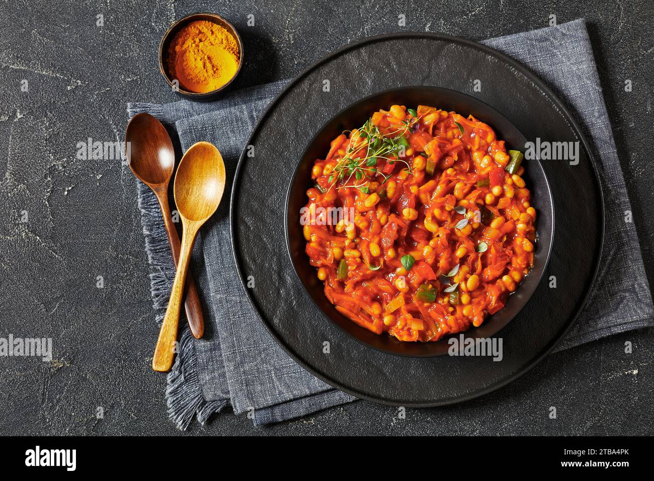 chakalaka, refreshing spicy tomato bean relish in black bowl on grey ...