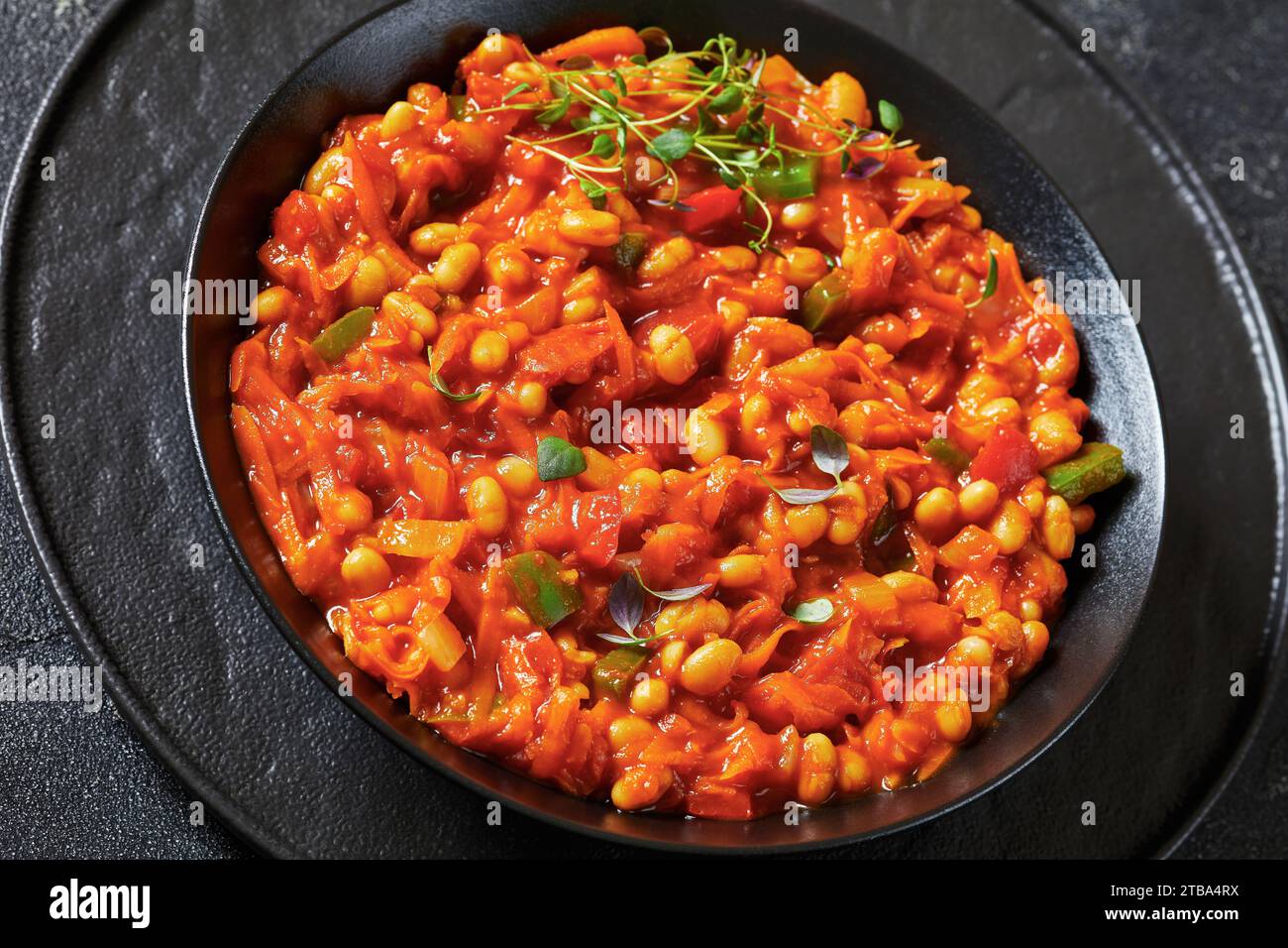 chakalaka, refreshing spicy tomato bean relish in black bowl on grey ...