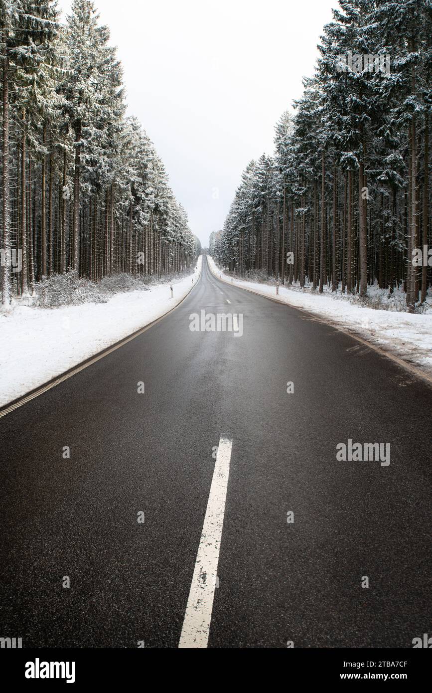 Road through a snow covered forest, slippery and frosty street in ...