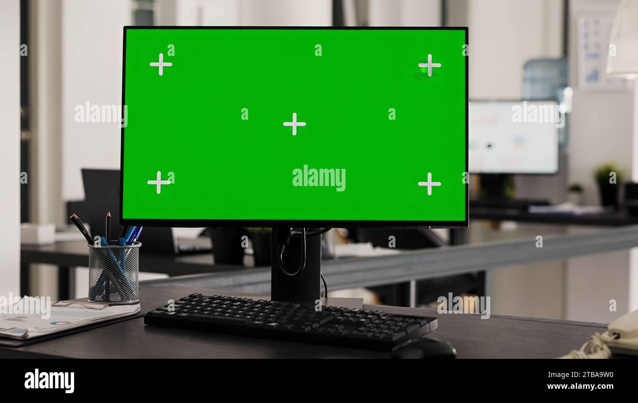 Greenscreen on office workstation placed in creative agency space, empty desk with pc running ...