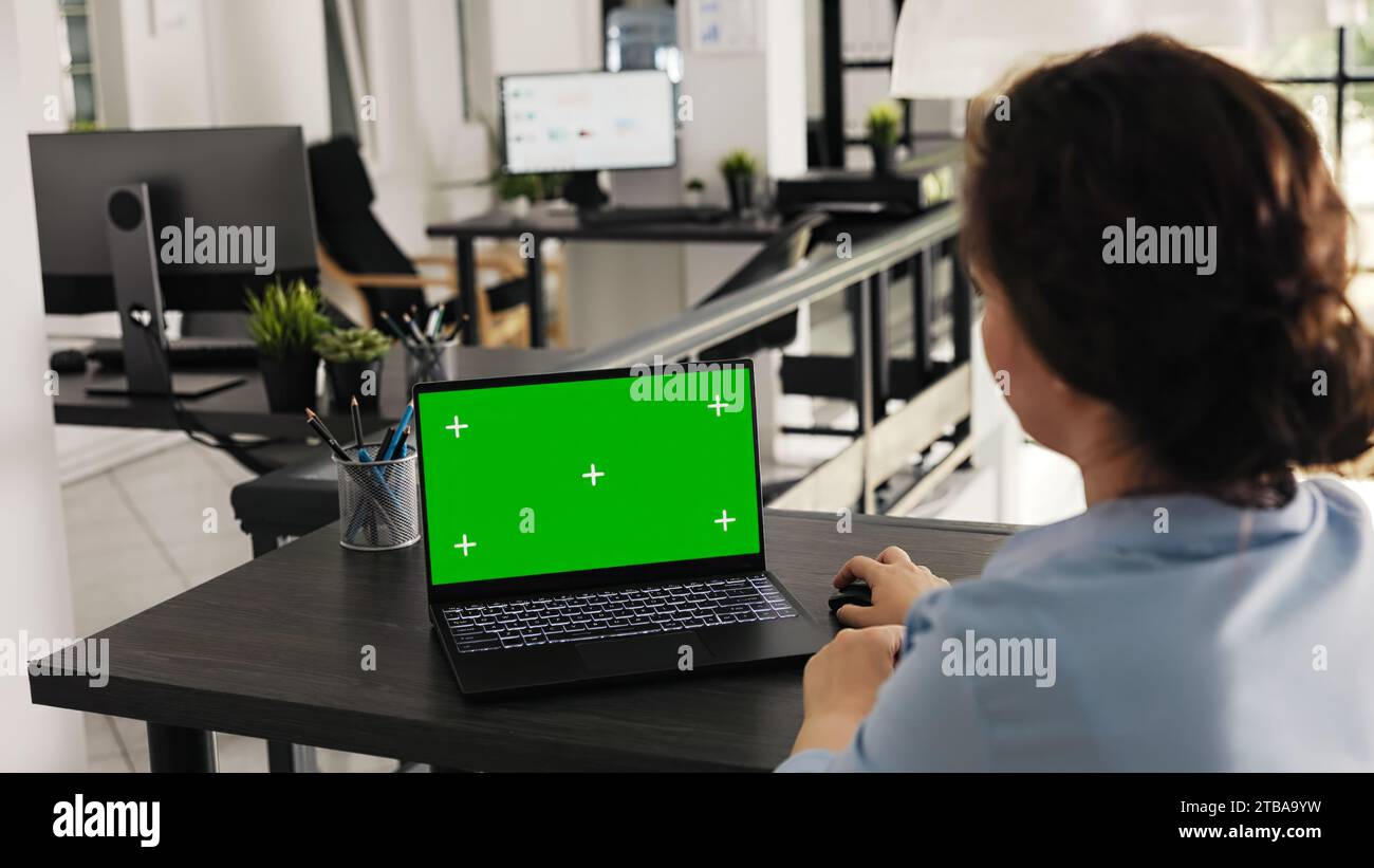 Employee uses greenscreen layout on laptop, working on business ...
