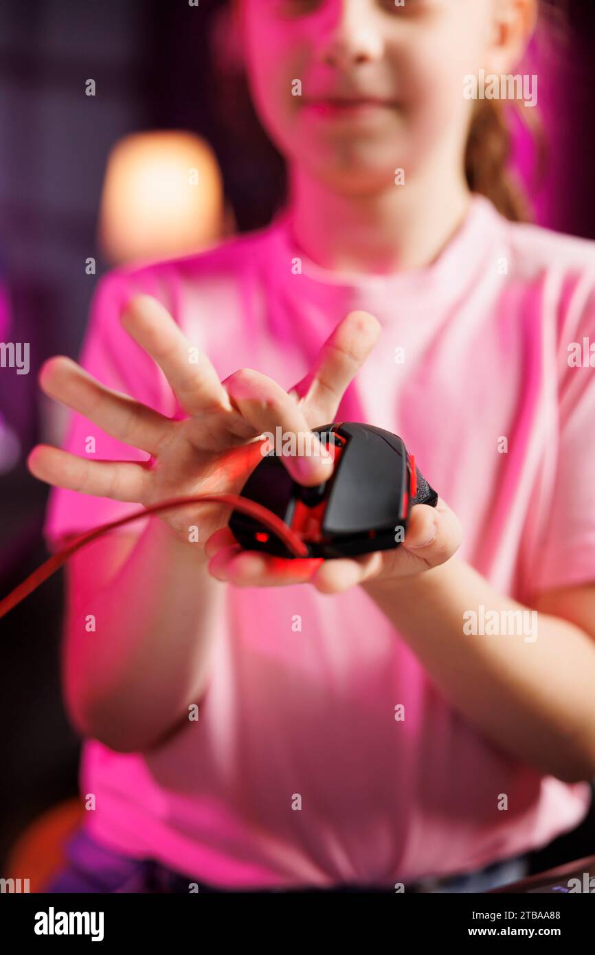 Close up shot of young girl in studio reviewing gaming mouse in front ...