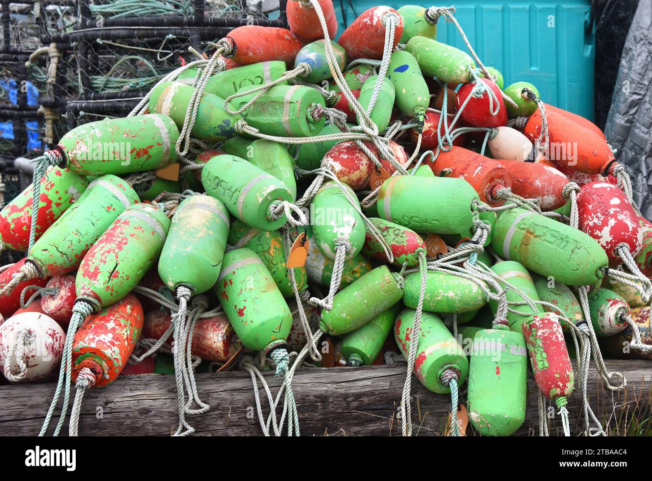 Pile of large floats, in green, red and white, lay in a pile on a dock ...