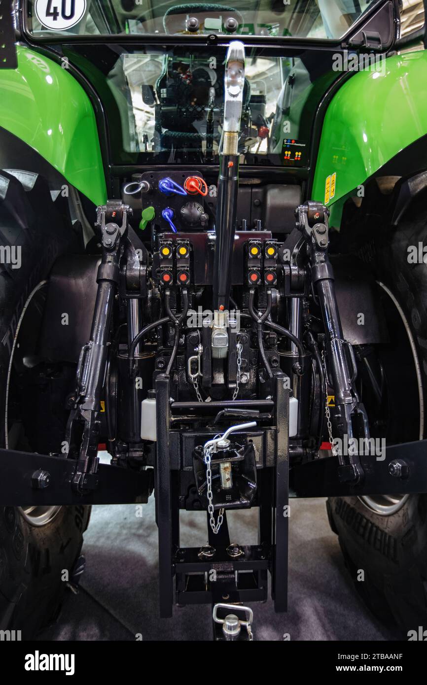 Rear view of modern agricultural tractor in hangar. Hydraulic hitch ...