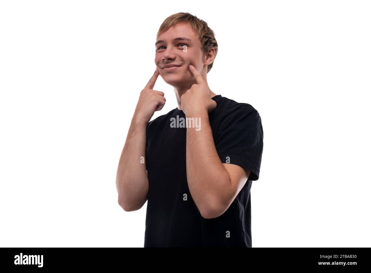 Blonde teenager dressed in a basic t-shirt rejoices on a white ...