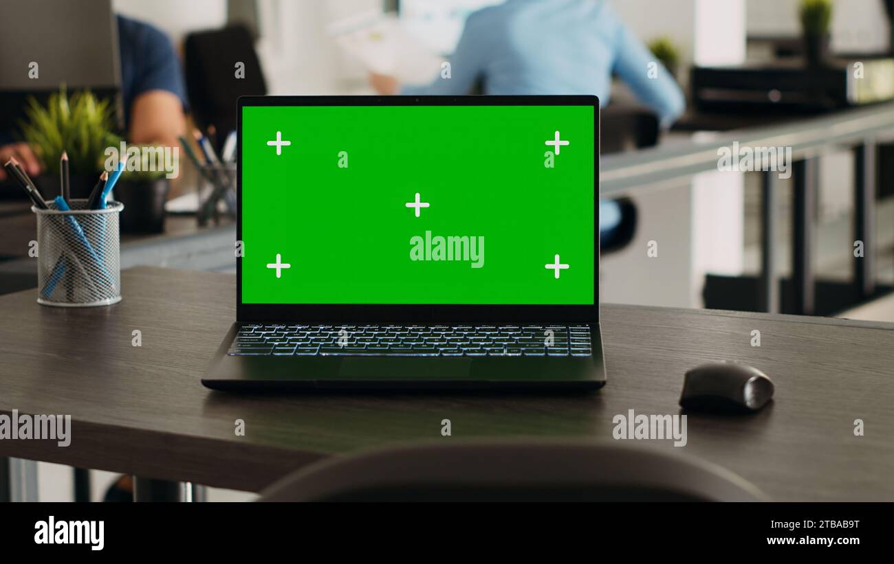 Wireless pc with greenscreen at empty desk in creative agency workplace ...
