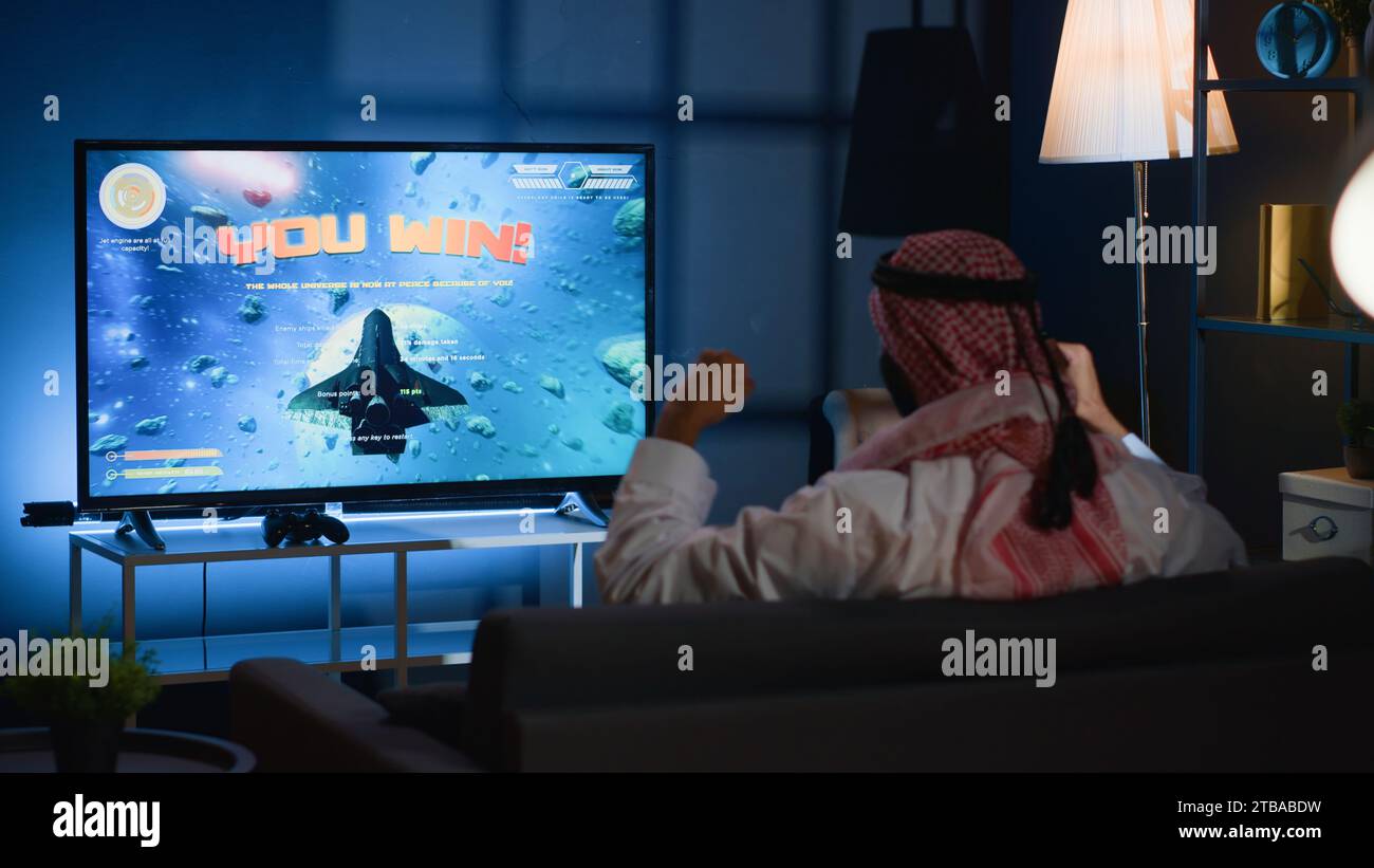Arab gamer excited after winning game playing arcade space shooter on ...