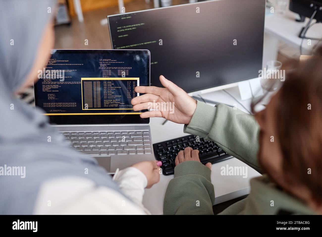 High angle closeup of two colleagues reviewing code in IT development ...