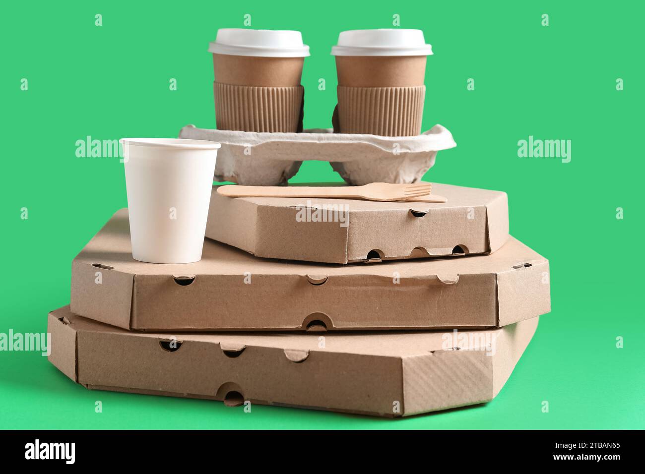 Takeaway paper cups, cutlery and different pizza boxes on green ...