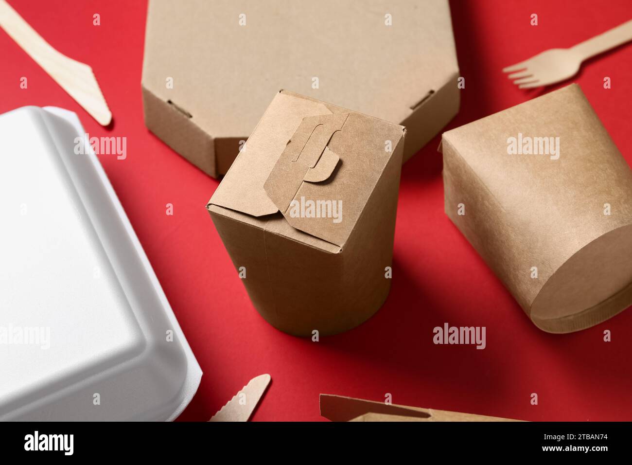 Different takeaway paper containers and cutlery on red background ...