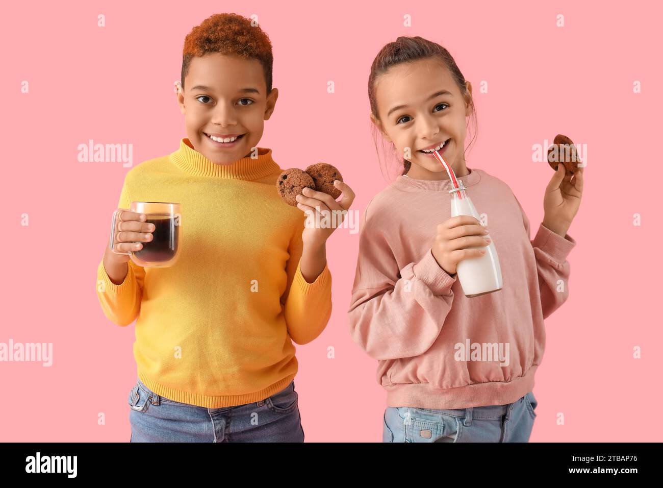 Little children eating cookies with hot chocolate and milk on pink ...