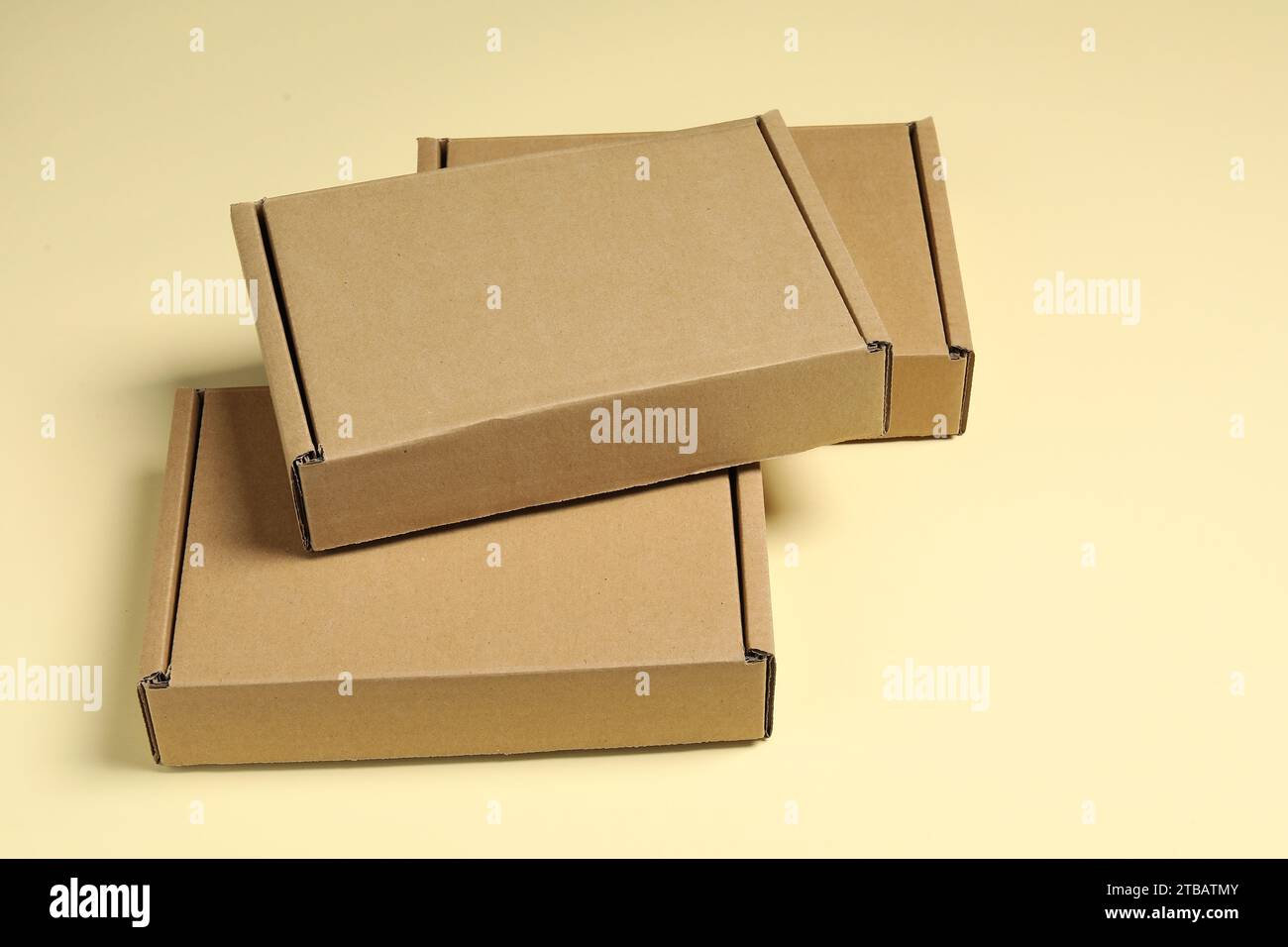 Many closed cardboard boxes on pale yellow background Stock Photo - Alamy