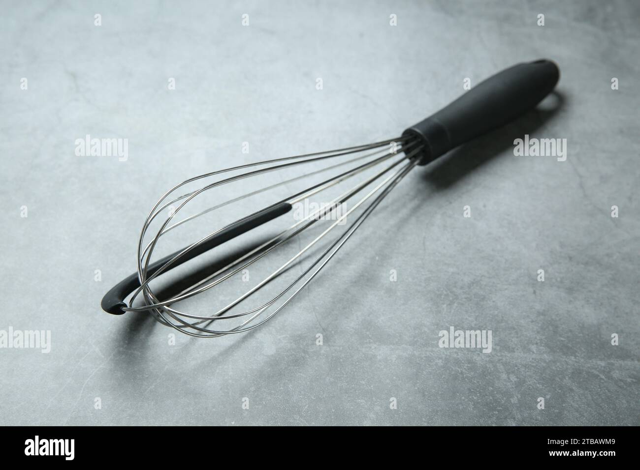 Metal whisk on gray table, closeup. Kitchen tool Stock Photo - Alamy